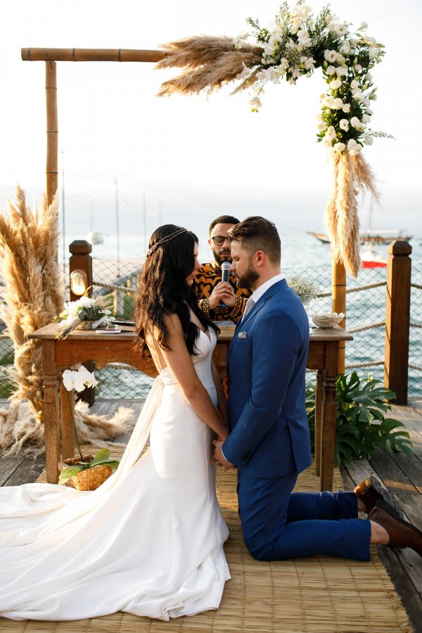 Destination wedding boho e com noivos elegantes no pier