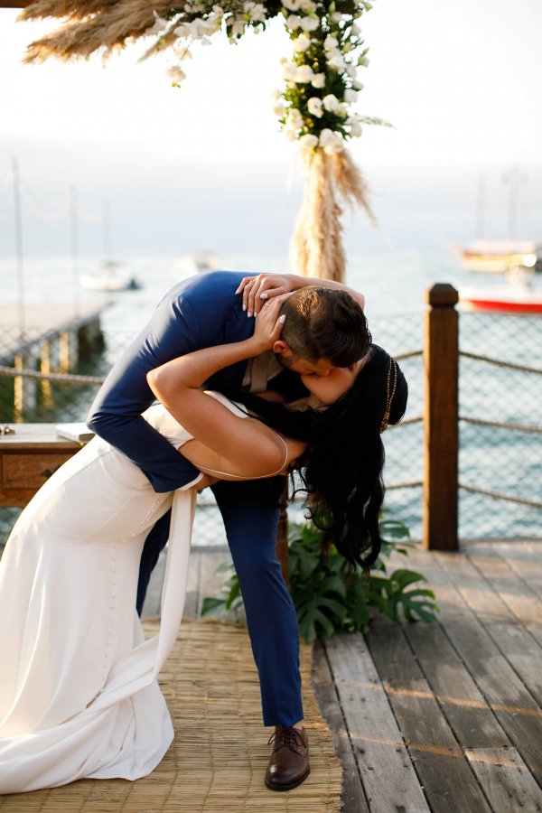 Destination wedding boho e com noivos elegantes no pier